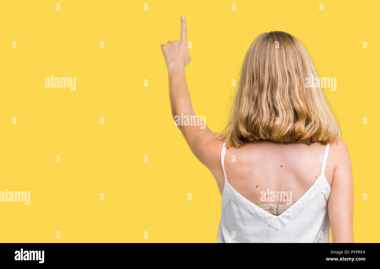 Beautiful young woman over isolated background Posing backwards ...