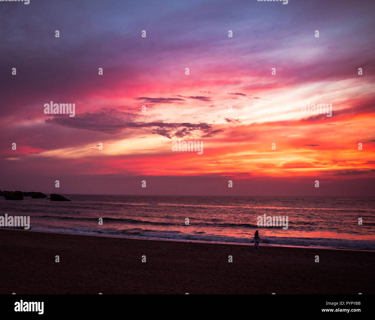 Girl enjoying a summer sunset on the beach called Grande Plage in ...