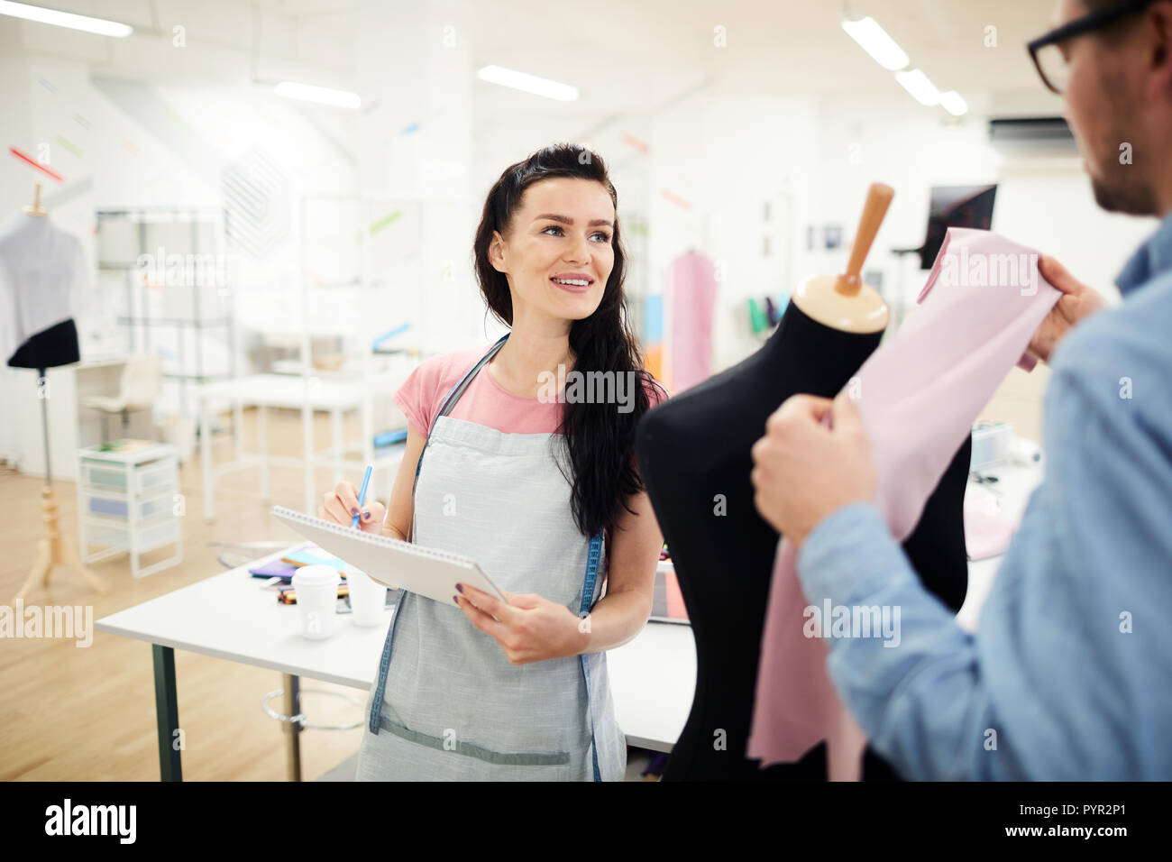 Happy woman making notes during individual tailoring course Stock Photo ...