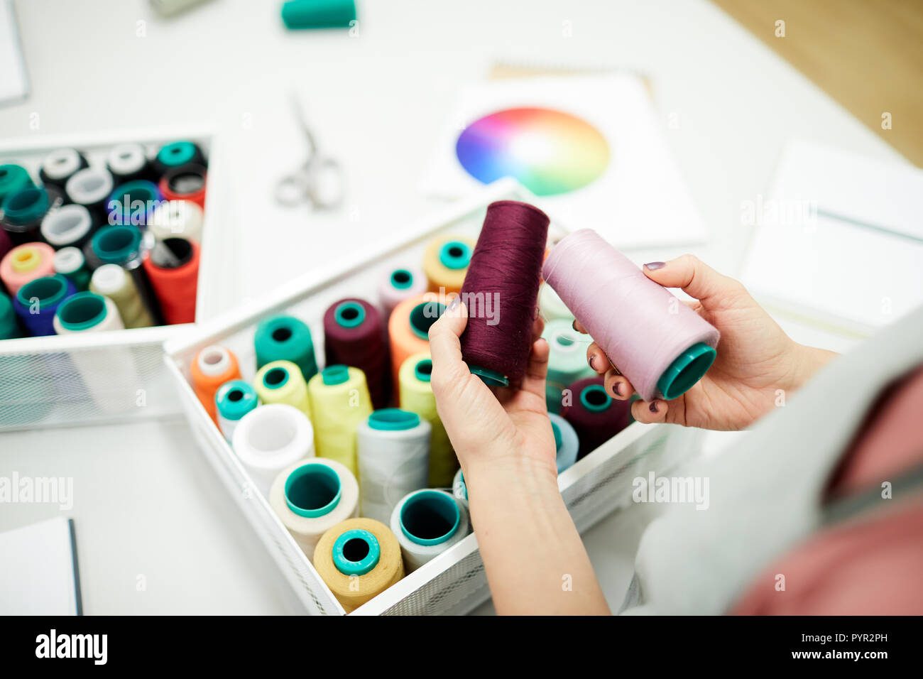 Woman matching thread for sewing Stock Photo - Alamy