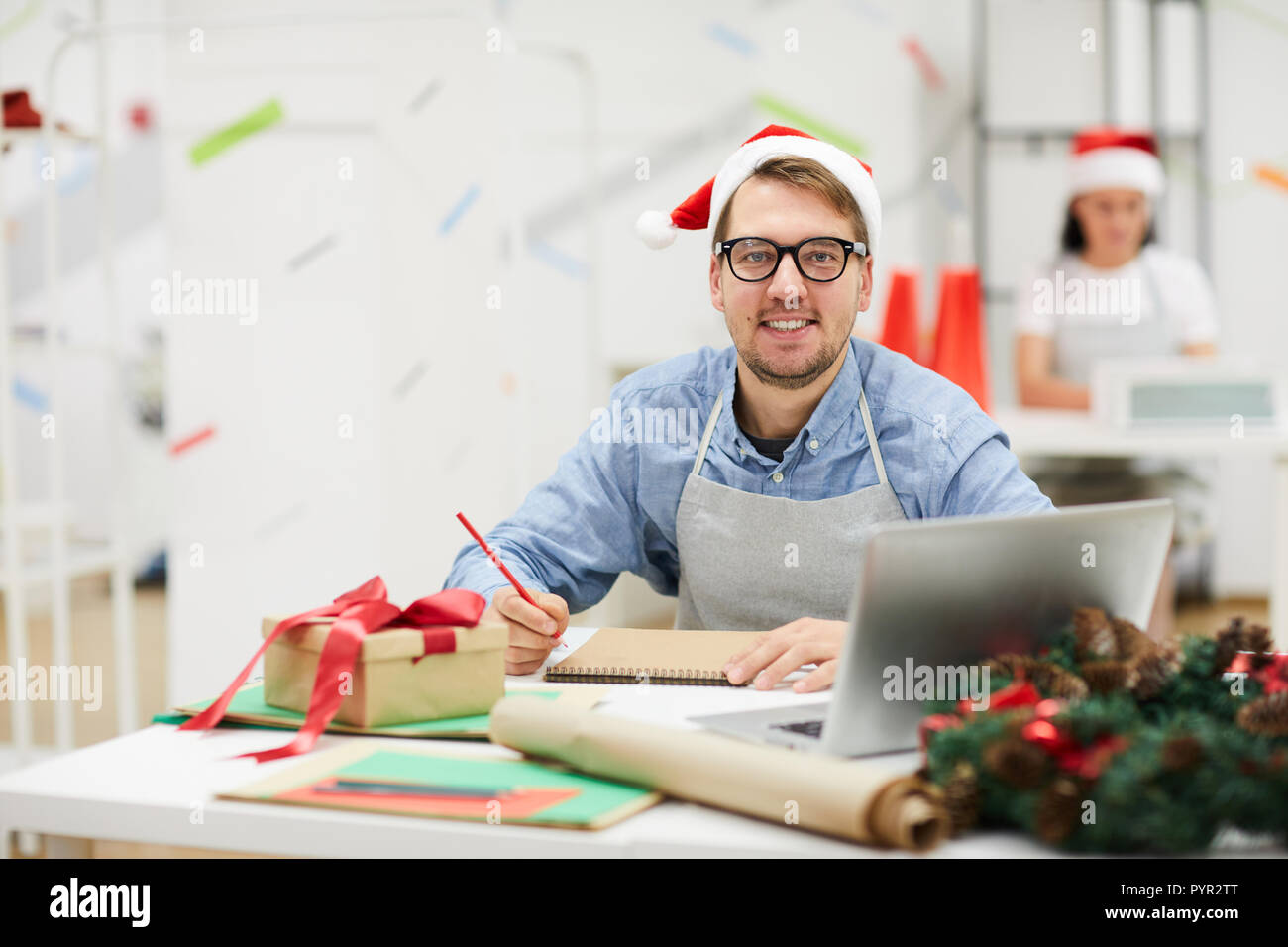 Happy creative designer in Santa hat Stock Photo - Alamy