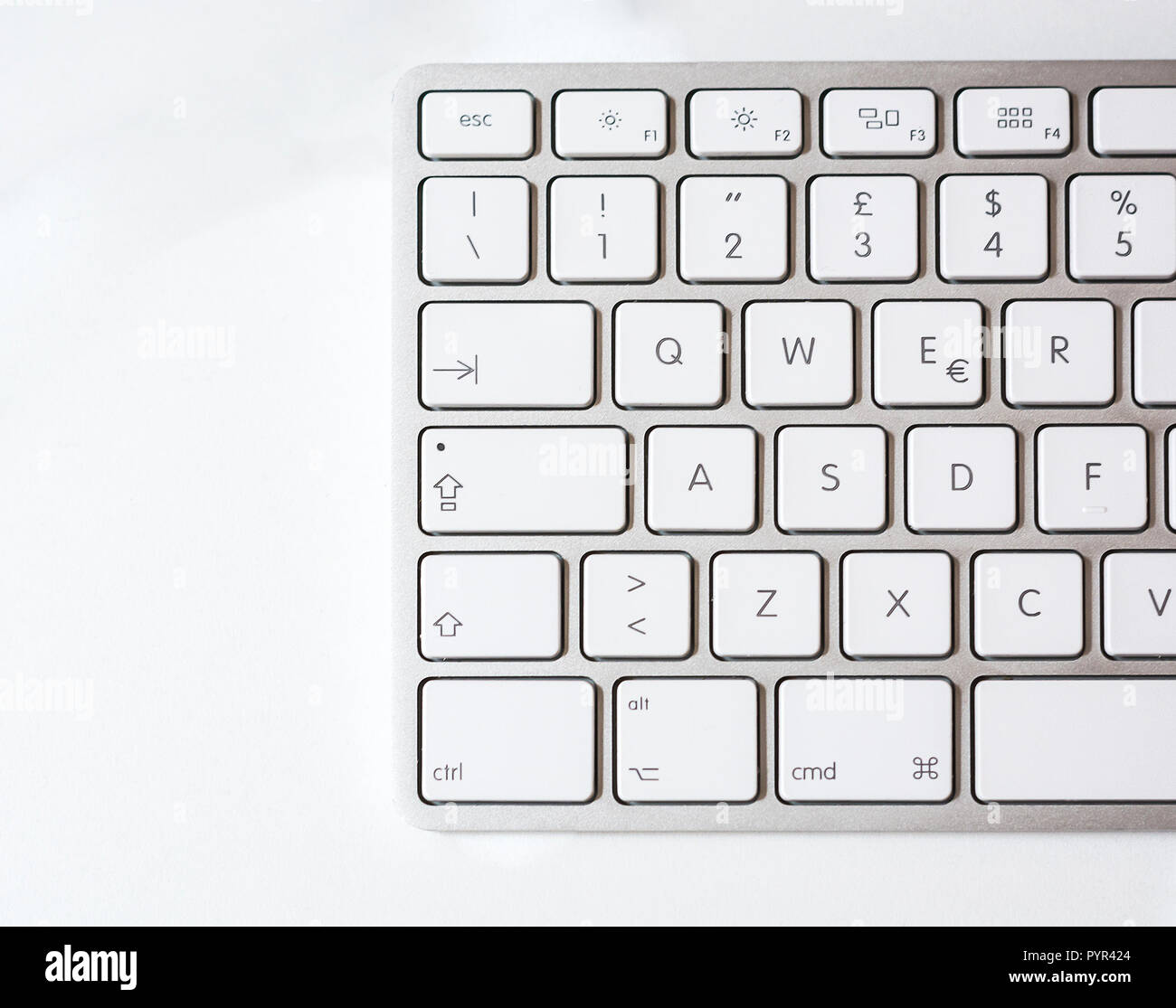 Detail of a modern aluminum computer keyboard with white keys view from ...