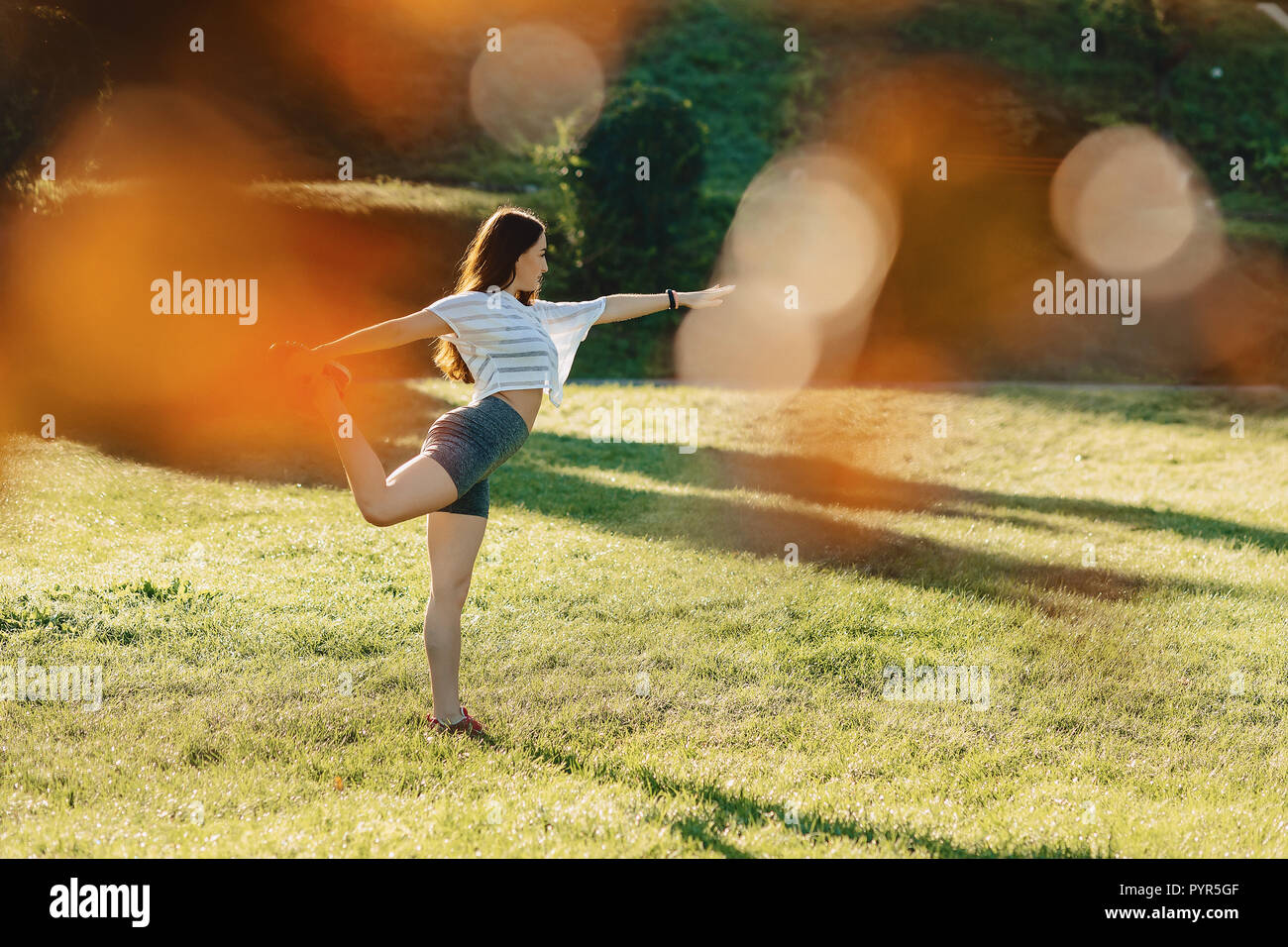 cozy fitness girl making morning stretching exercises outside on ...