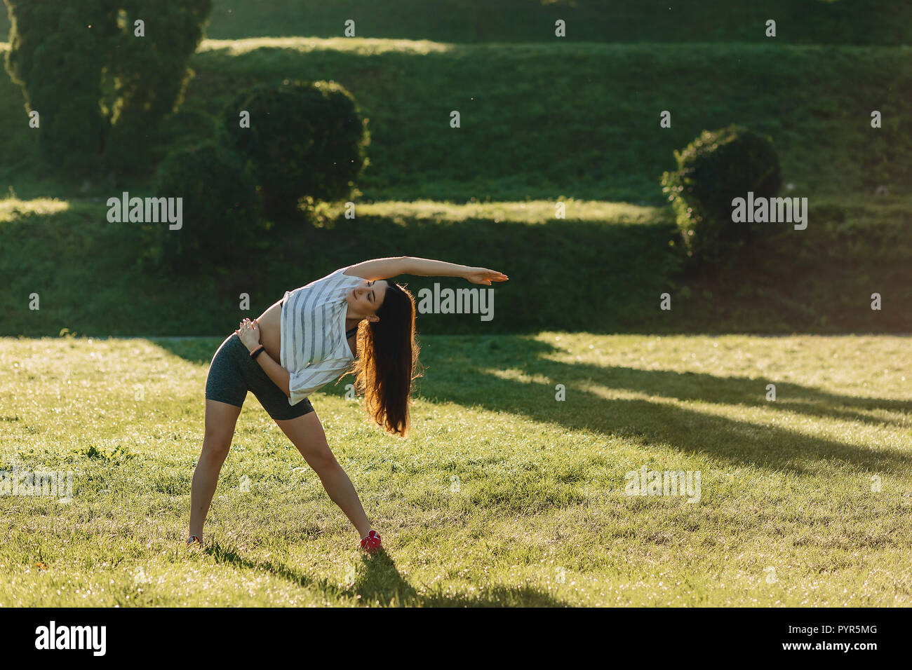 cozy fitness girl making morning stretching exercises outside on ...