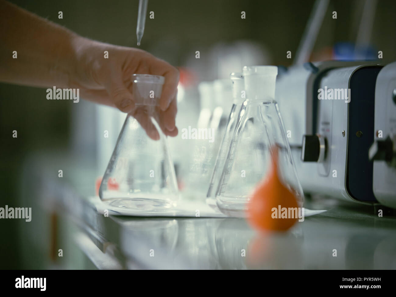 Table full of flasks. Chemical lab. Hands Stock Photo - Alamy