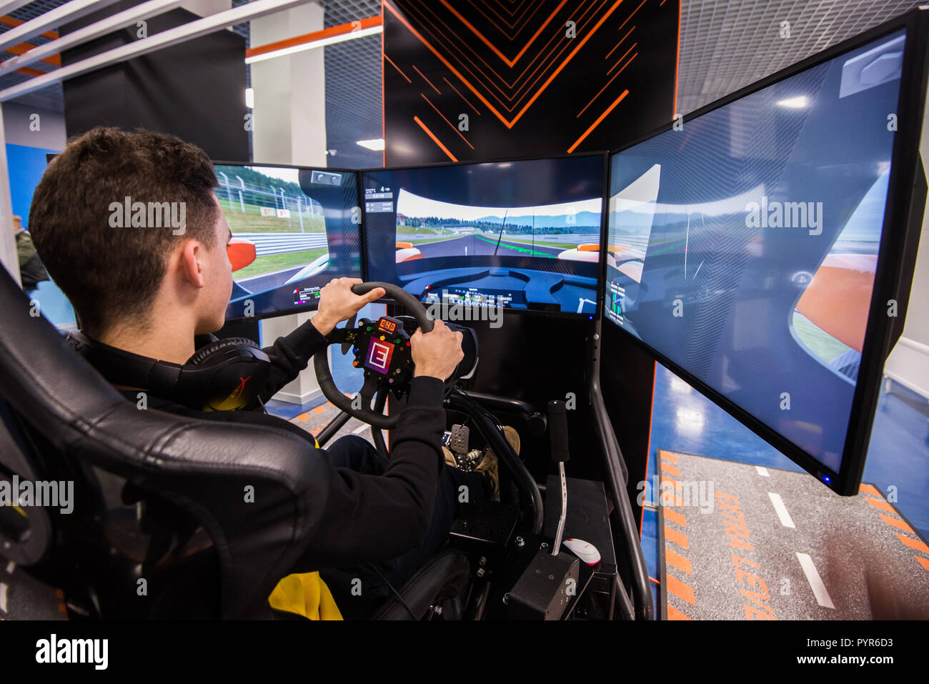 MOSCOW, RUSSIA - OCTOBER 27 2018. Young man plays on a computer racing ...