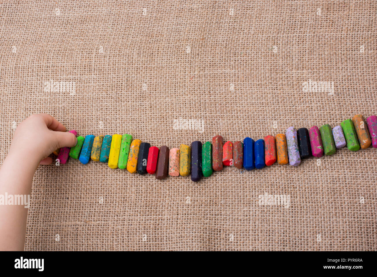 Toddlers hand putting crayons in line on canvas Stock Photo - Alamy