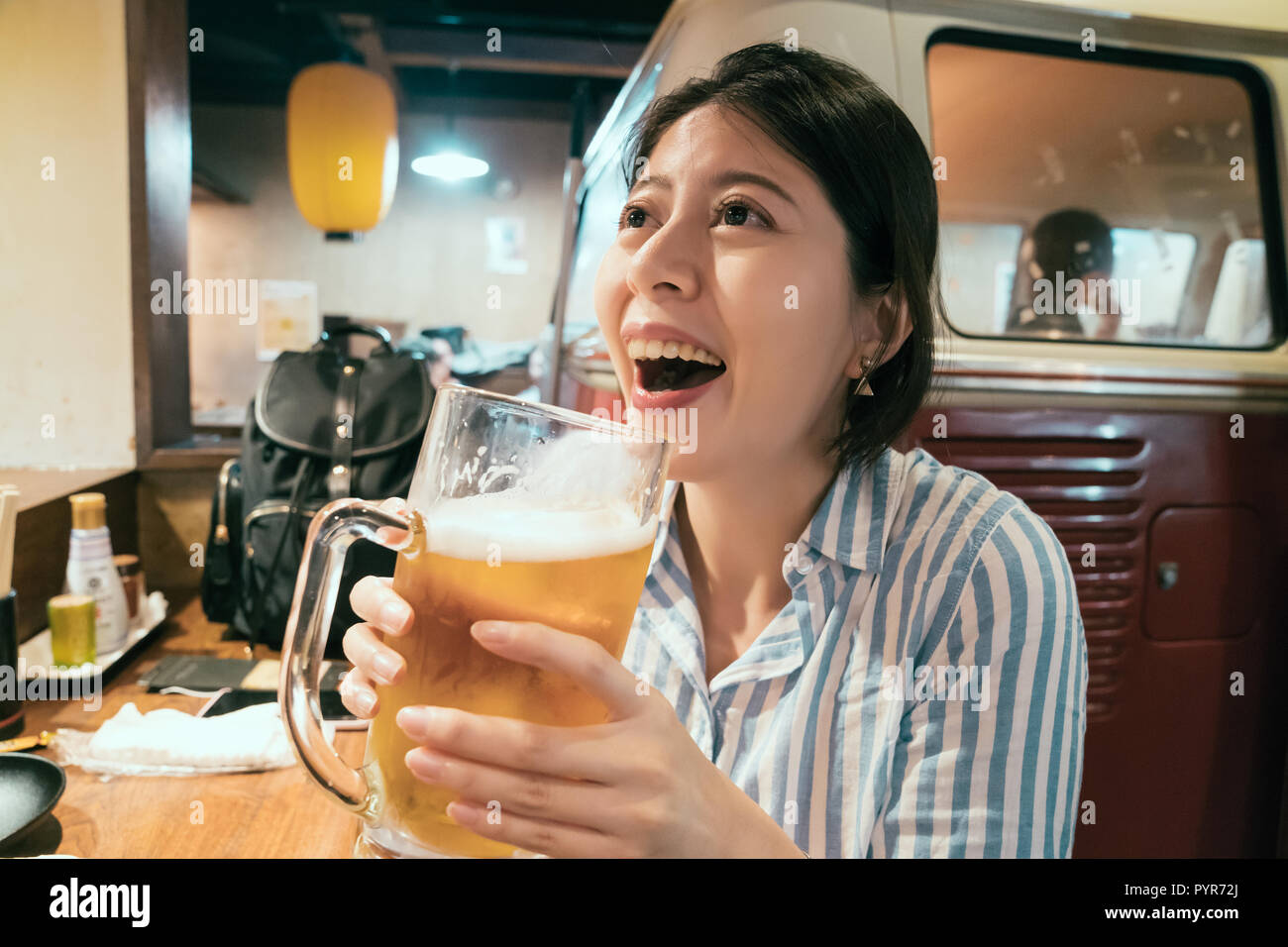 japanese lady holding beer in izakaya. cheerful office lady having ...