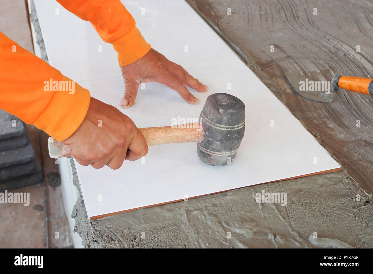 Construction worker tiler is tiling, Tiler installing ceramic tiles on ...