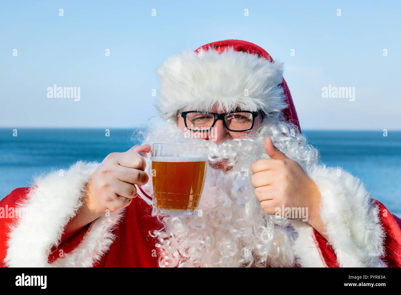 Fat man dressed as Santa drinking beer on the ocean Stock Photo - Alamy