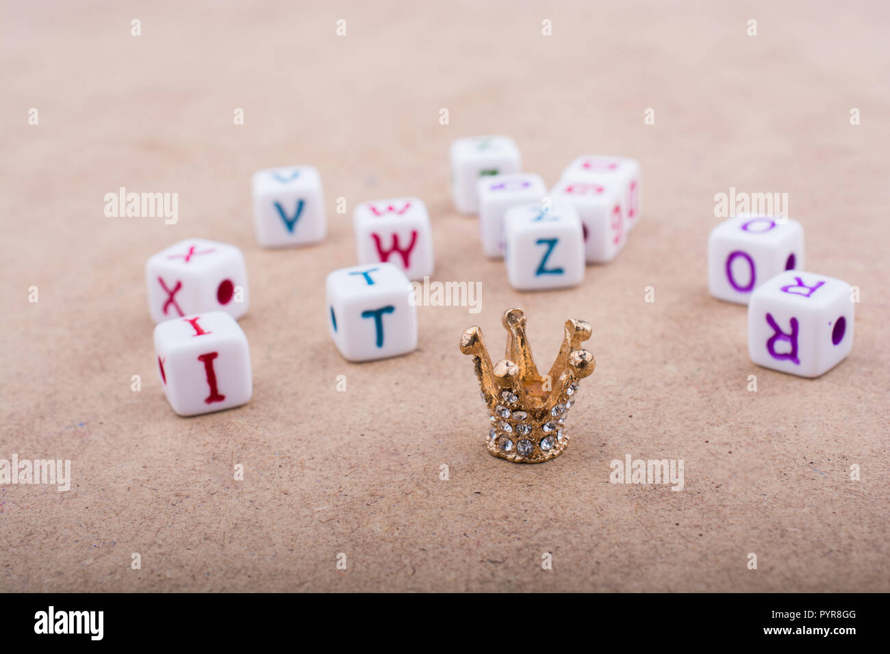 Golden color crown model in front of the letter cubes Stock Photo - Alamy
