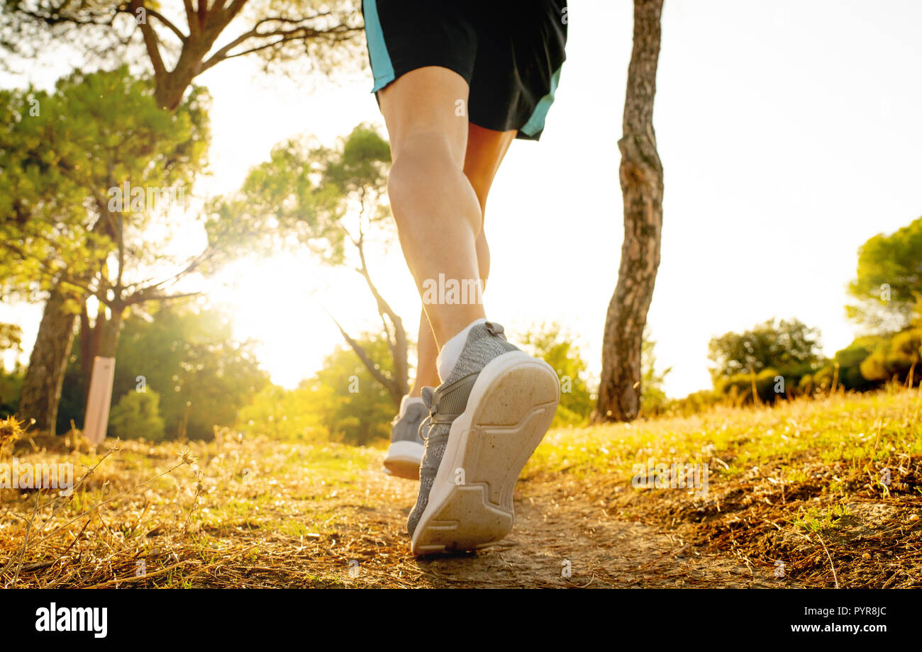 Back view of sport man with ripped athletic and muscular legs running ...