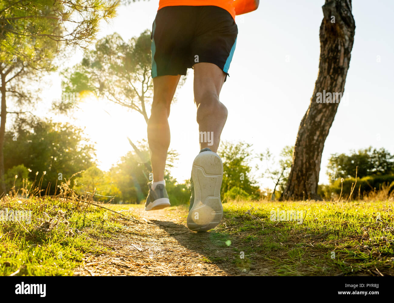 Back view of sport man with ripped athletic and muscular legs running ...