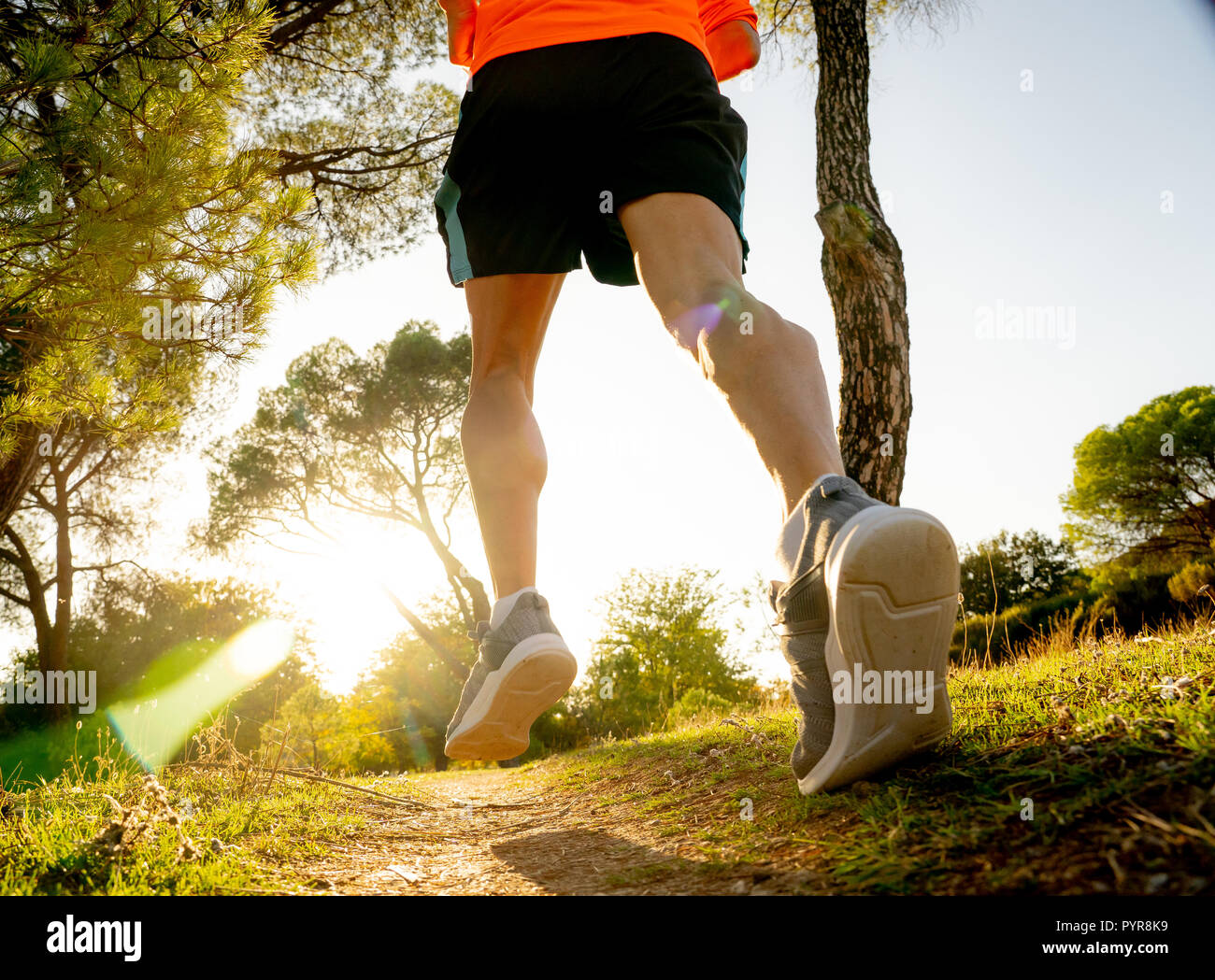 Back view of sport man with ripped athletic and muscular legs running ...