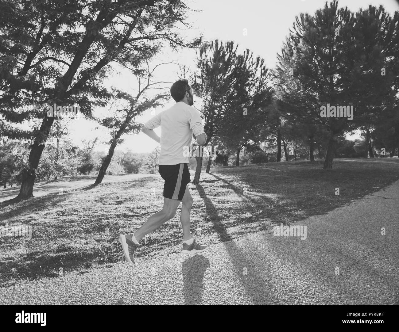 Back view of sport man with ripped athletic and muscular legs running ...