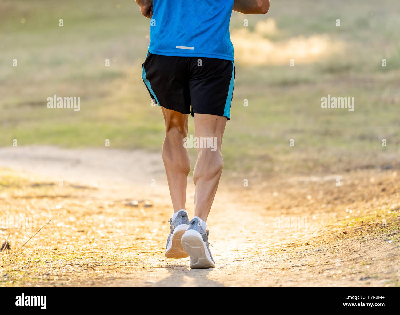 Back view of sport man with ripped athletic and muscular legs running ...