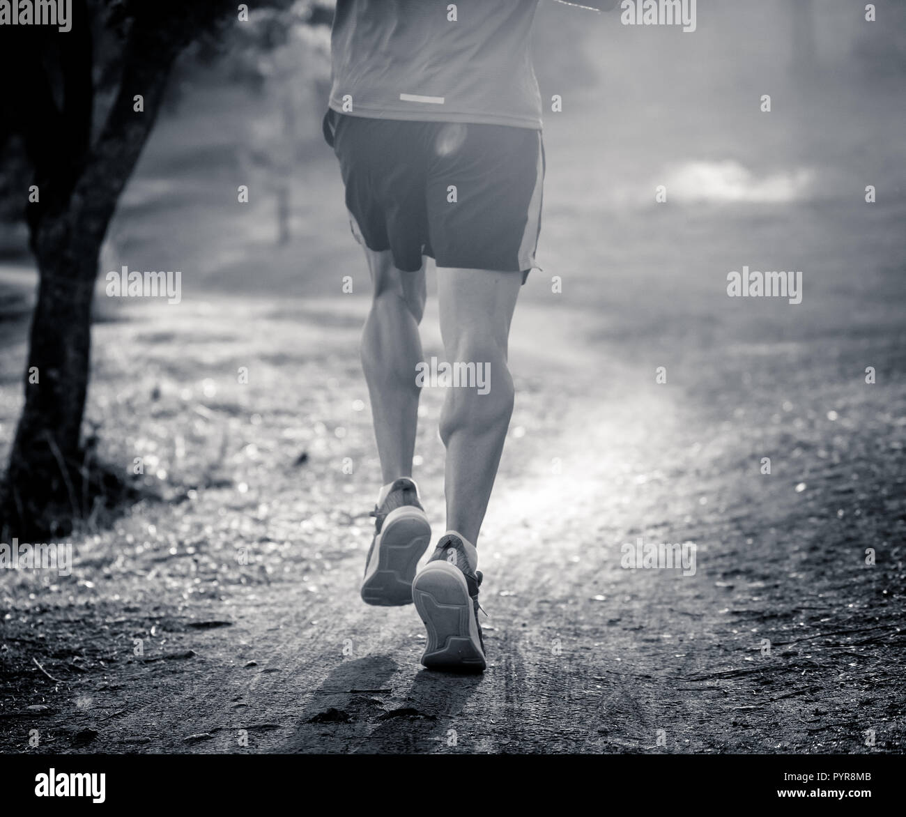 Back view of sport man with ripped athletic and muscular legs running ...