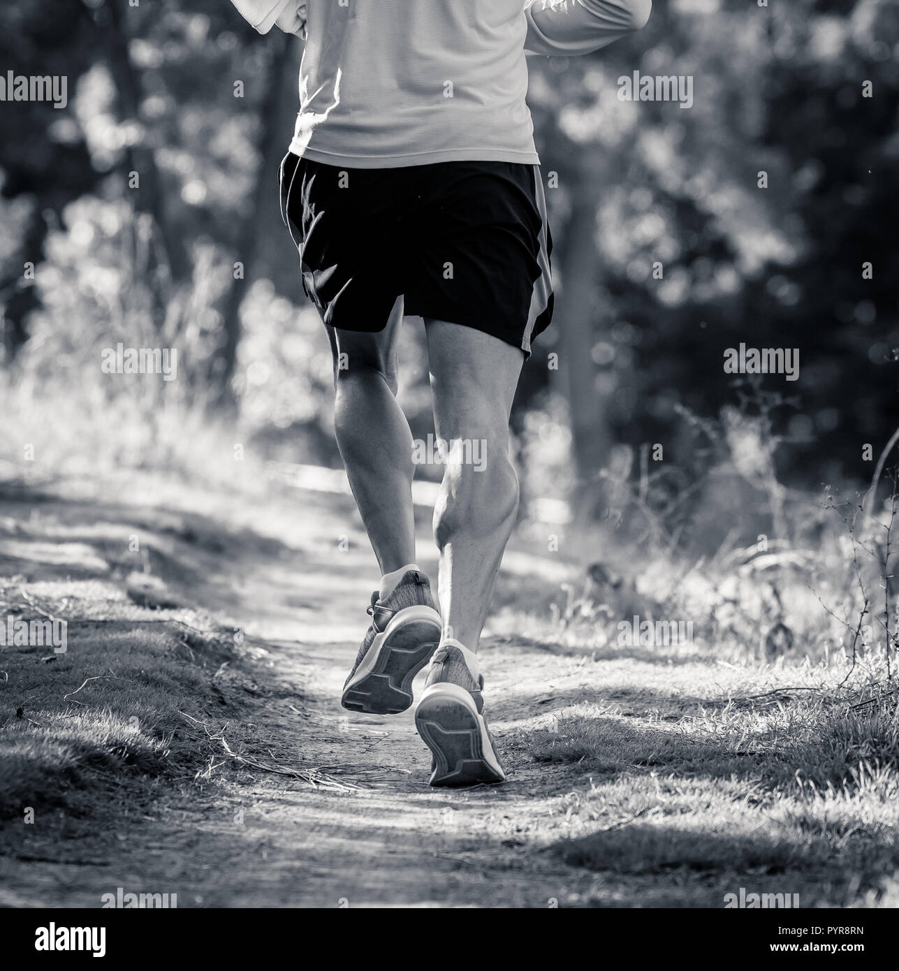 Back view of sport man with ripped athletic and muscular legs running ...