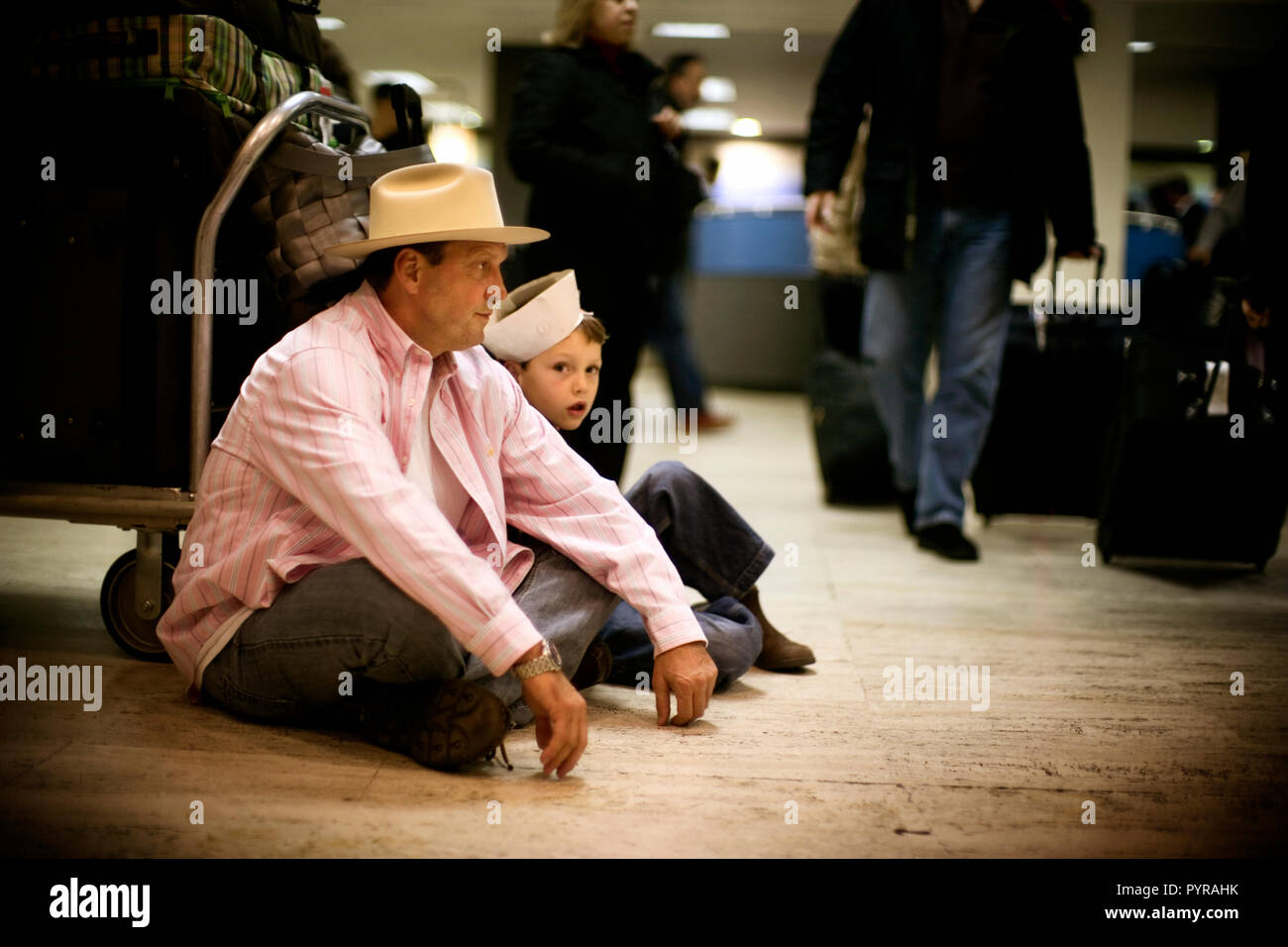 View of a father and a son sitting in a waiting room Stock Photo - Alamy