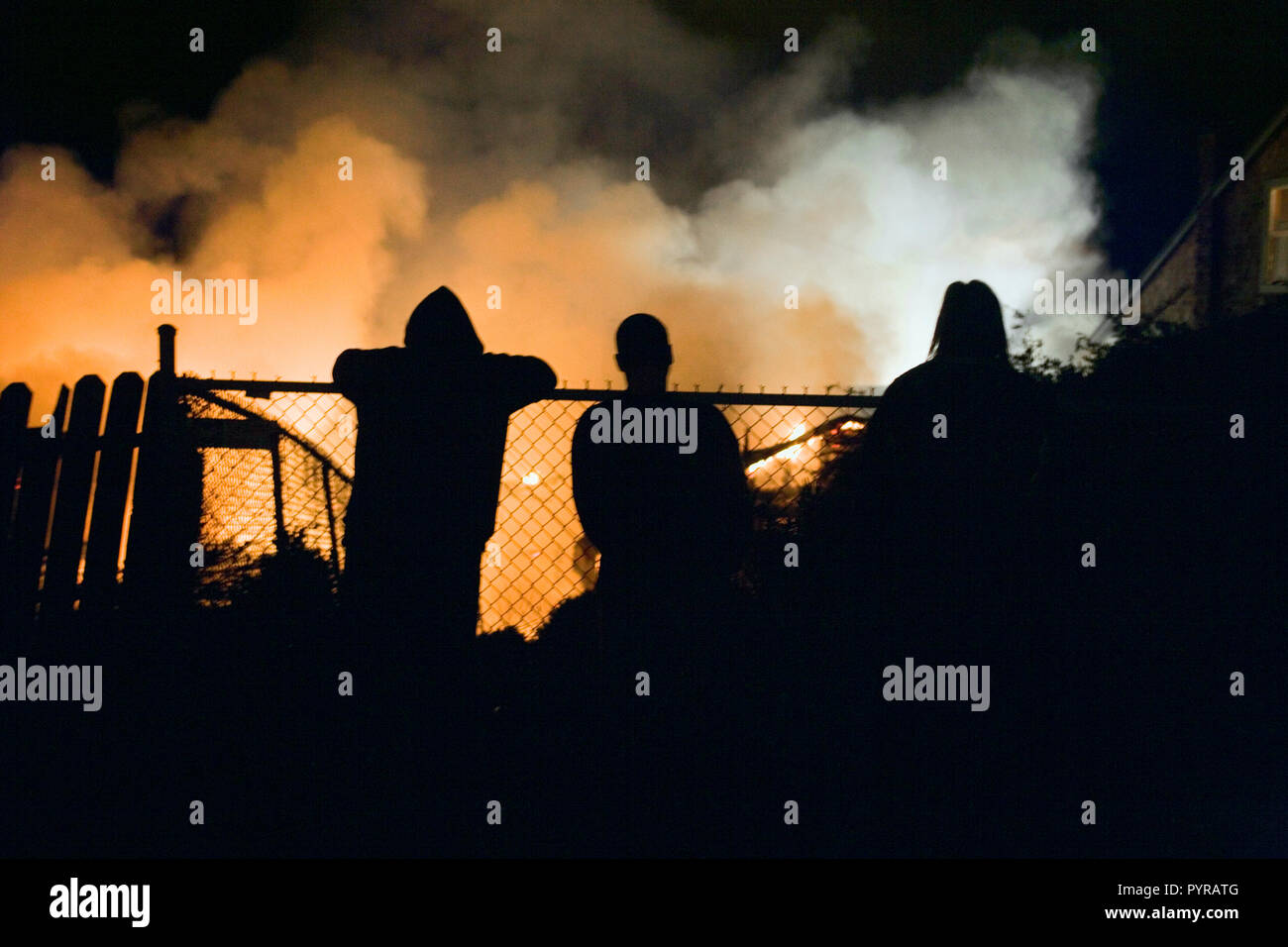 View of three people watching a blazed fire Stock Photo - Alamy