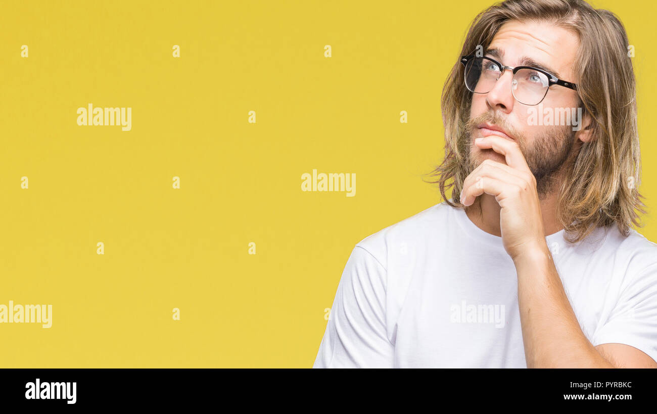Young handsome man with long hair wearing glasses over isolated ...