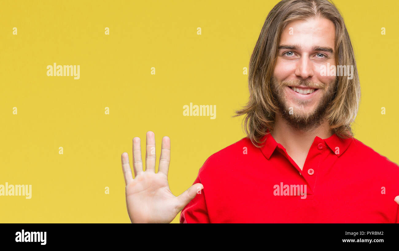 Young handsome man with long hair over isolated background showing and ...