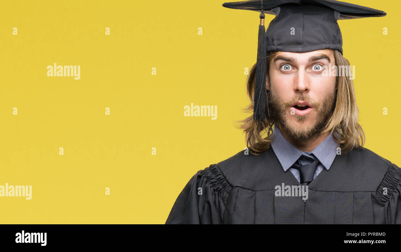 Young handsome graduated man with long hair over isolated background ...