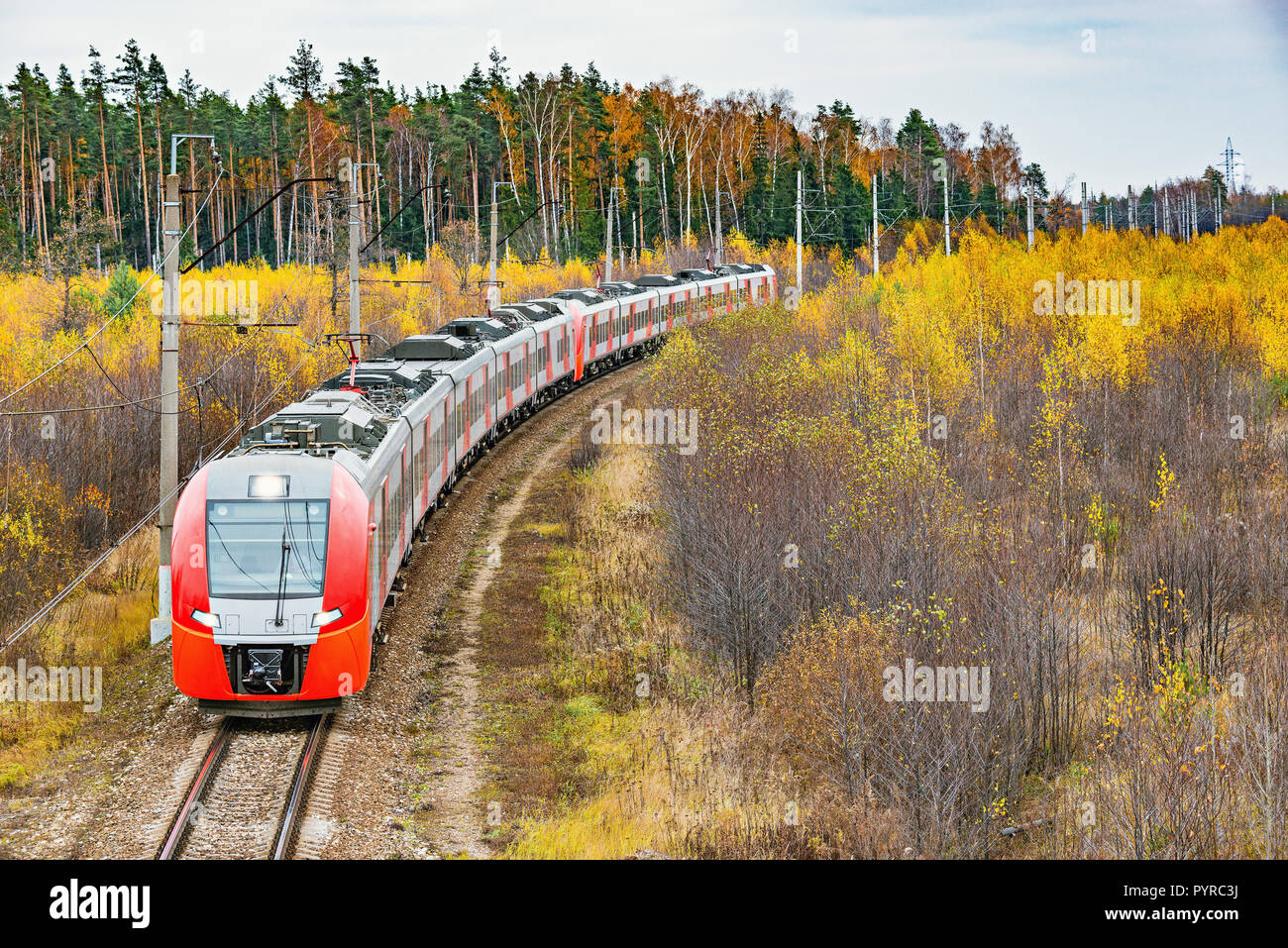 Modern high-speed train approaches to the station at autumn morning ...