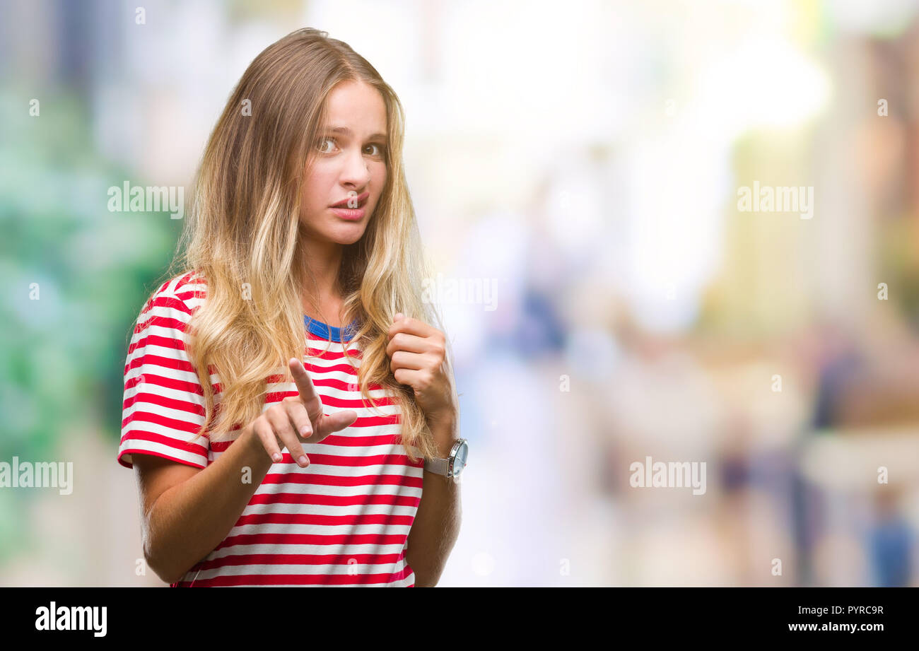 Young beautiful blonde woman over isolated background disgusted ...