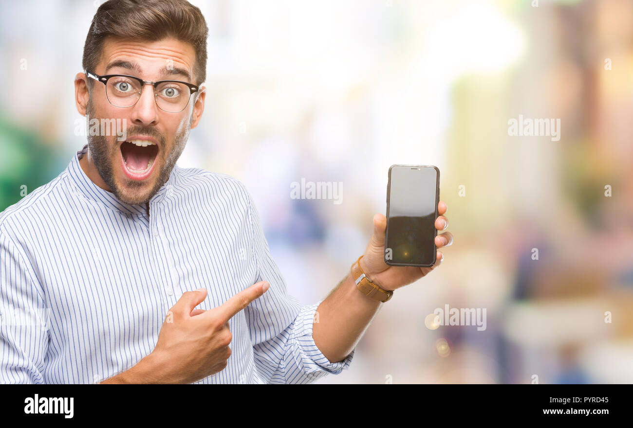 Young handsome man texting using smartphone over isolated background ...
