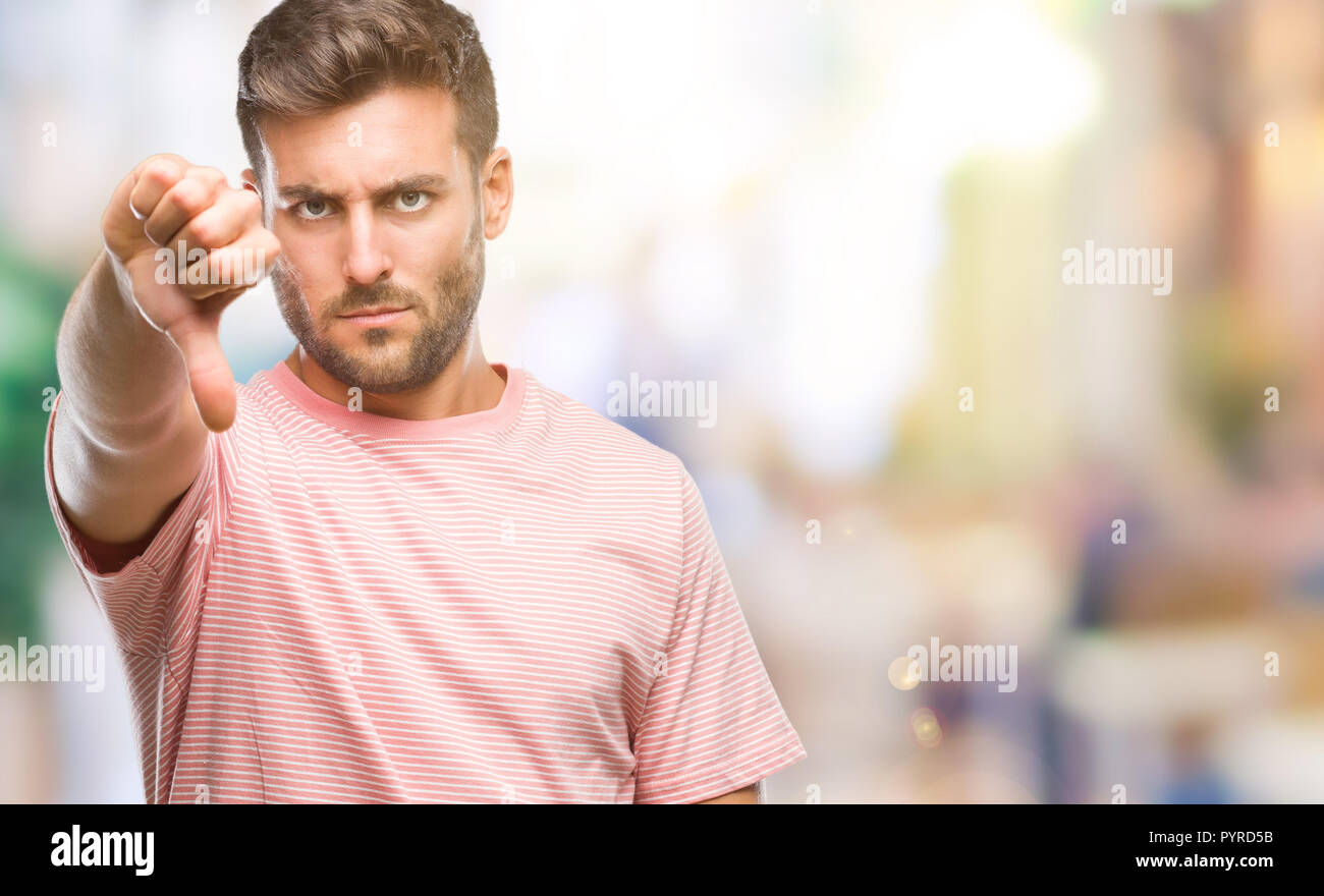 Young handsome man over isolated background looking unhappy and angry ...