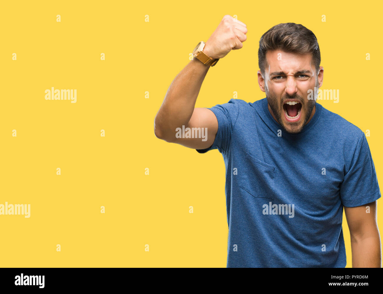 Young handsome man over isolated background angry and mad raising fist ...