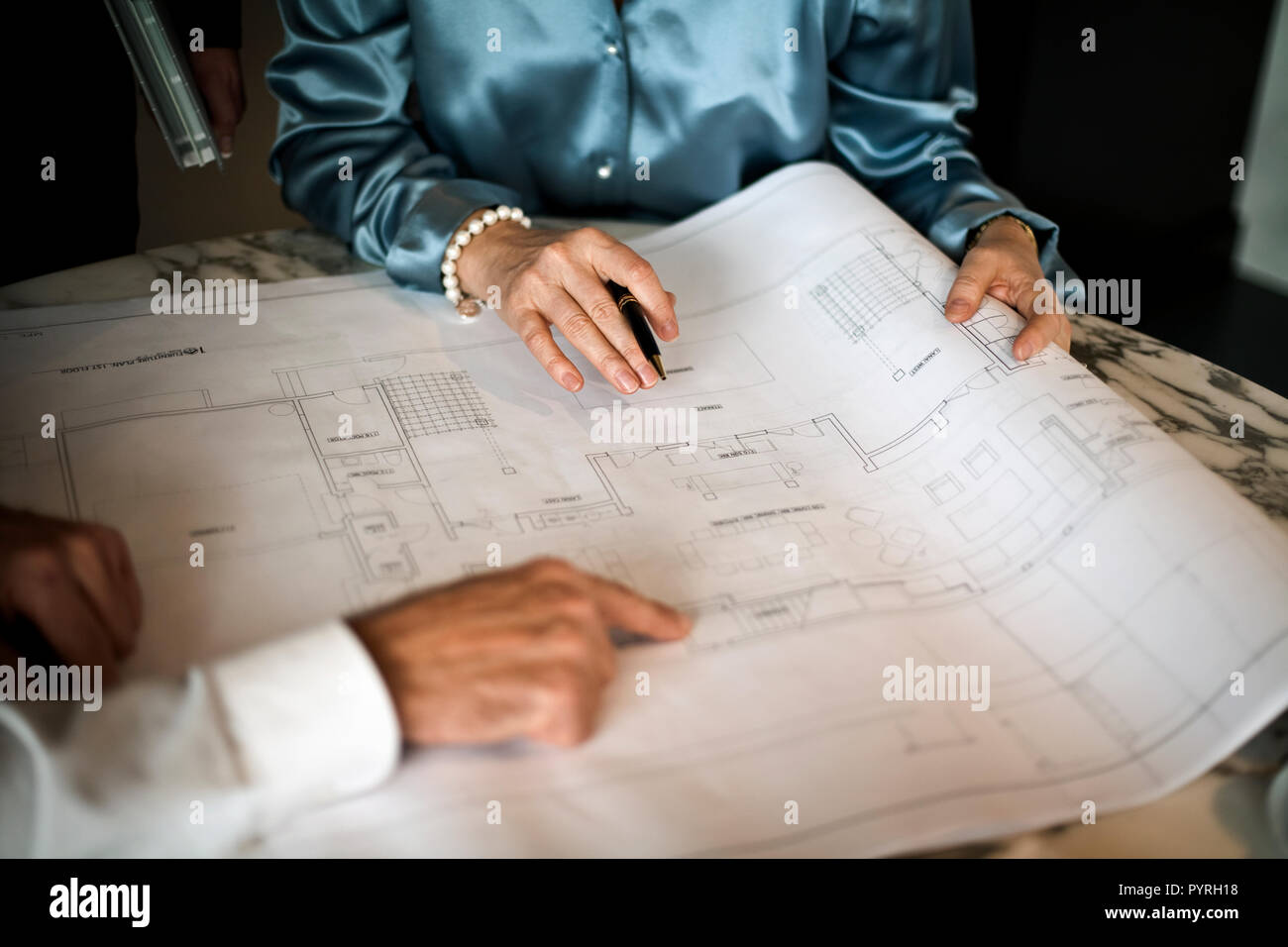 People working on architectural blueprint Stock Photo - Alamy
