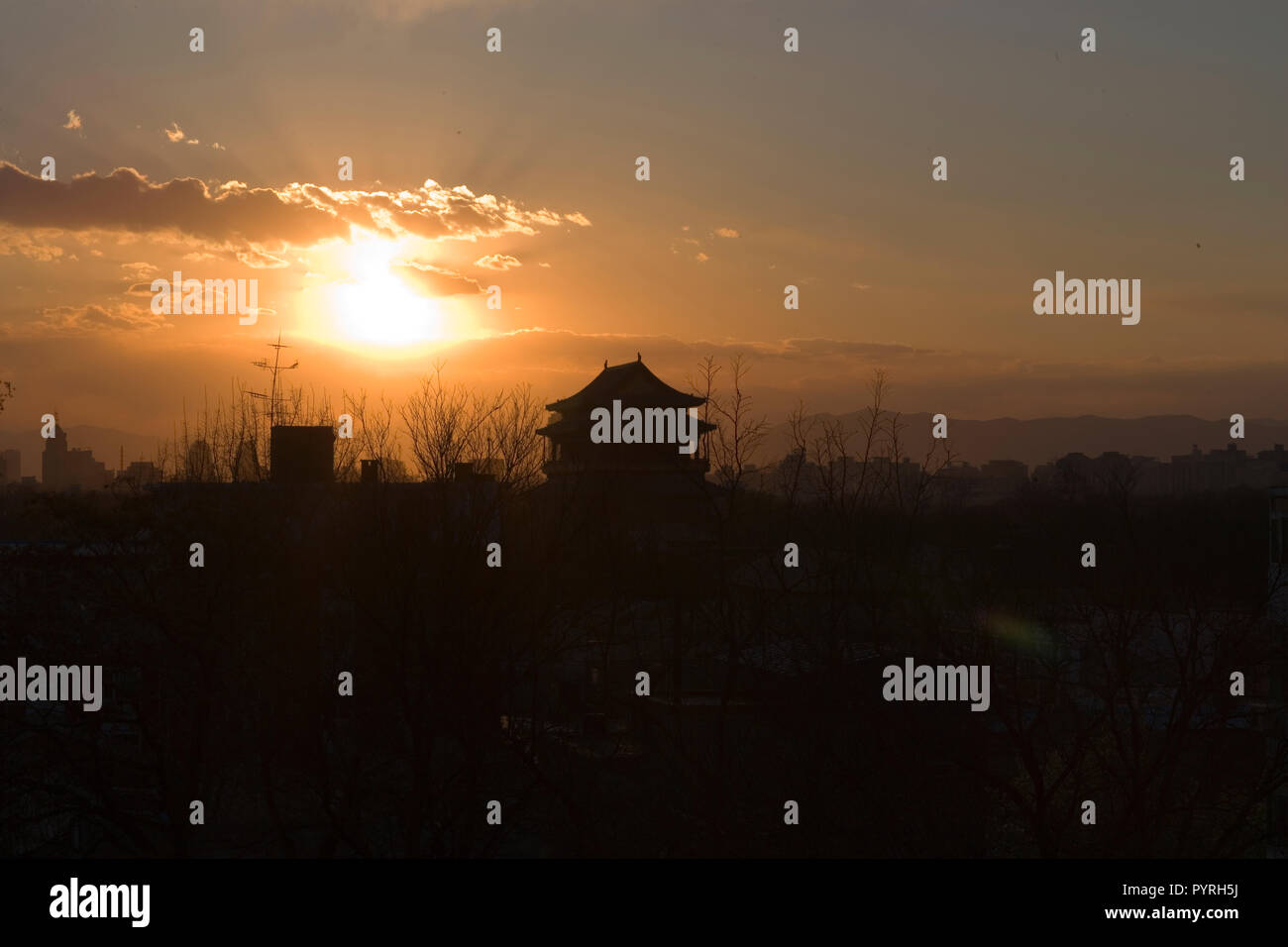 Sun setting over a city scape Stock Photo - Alamy