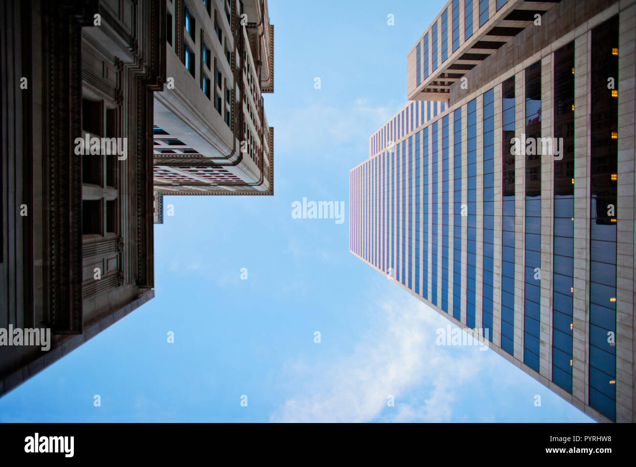 Cloudy blue sky seen from underneath skyscrapers Stock Photo - Alamy