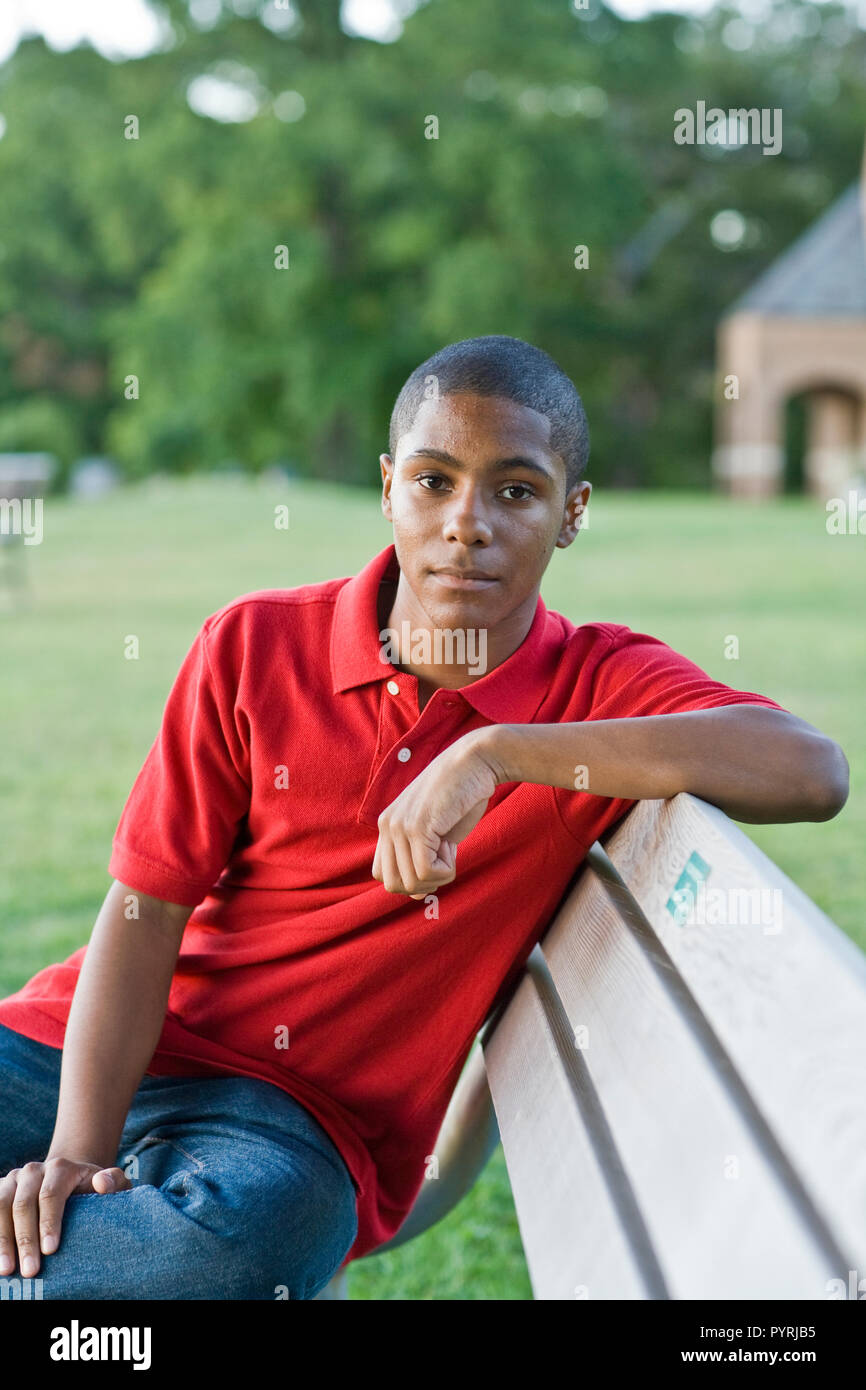 Portrait of teenage boy sitting on bench Stock Photo - Alamy