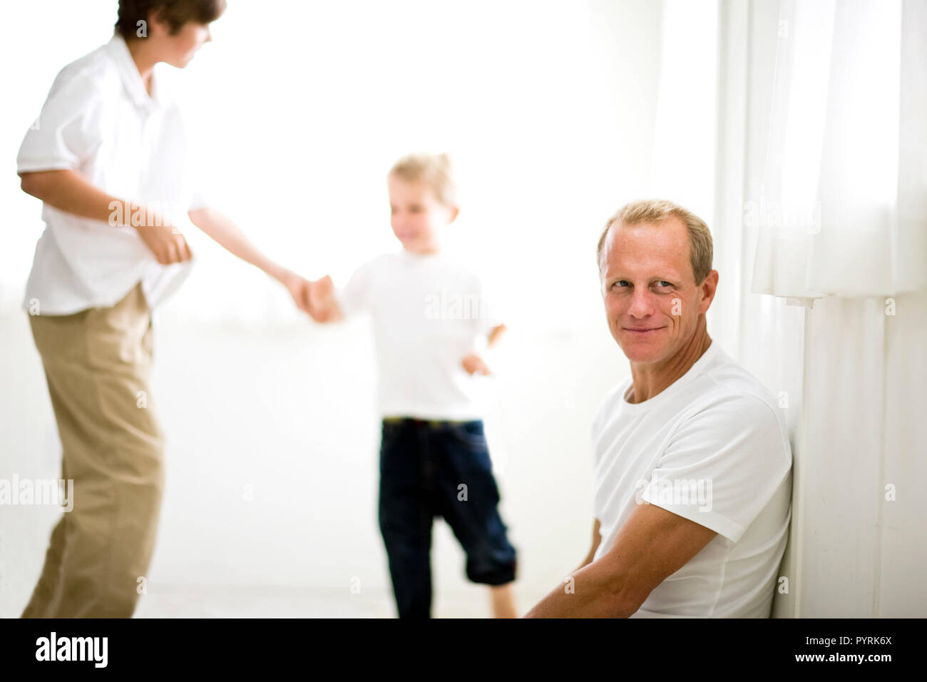 Father playing with his two young sons inside his home Stock Photo - Alamy
