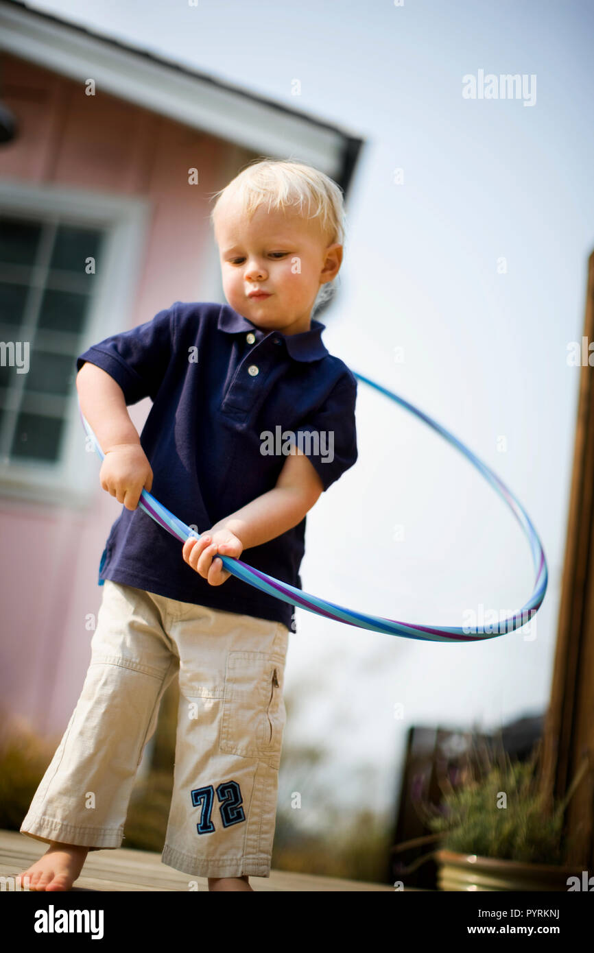 Blond toddler playing with a hula hoop Stock Photo - Alamy