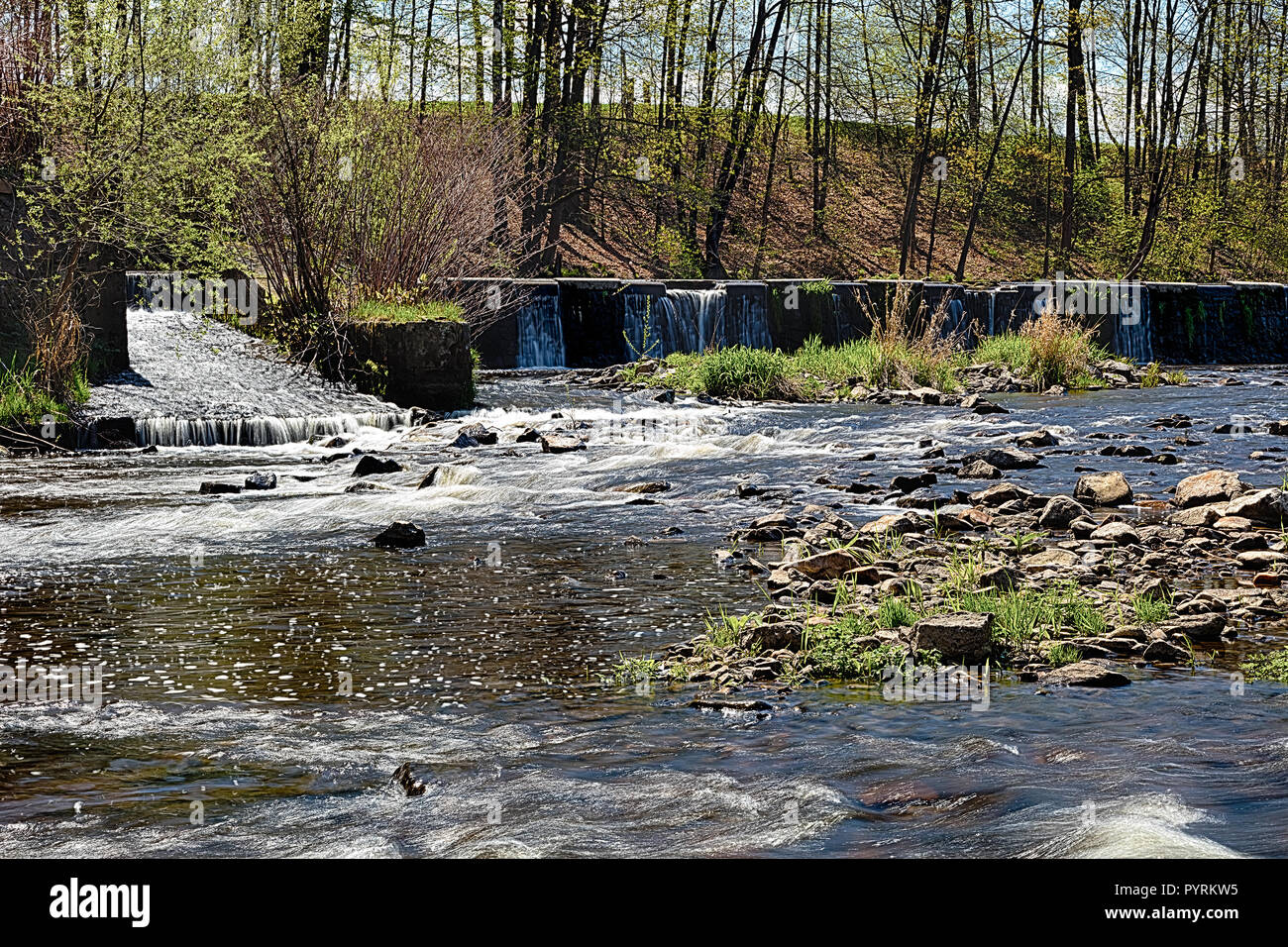 River with the weir runs over boulders Stock Photo - Alamy