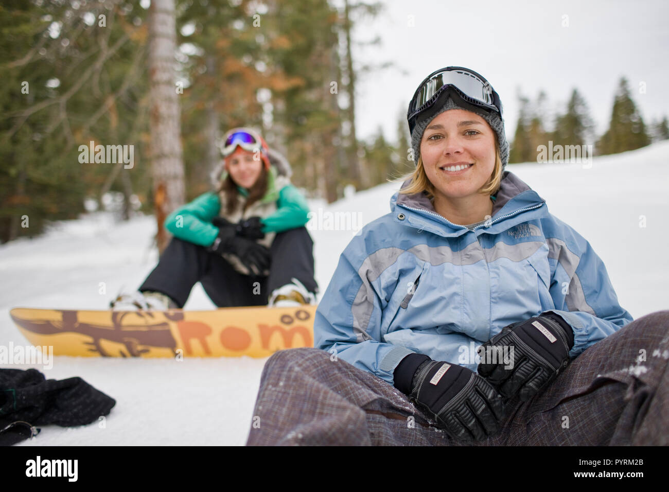 Women sitting with snowboards on mountain Stock Photo - Alamy