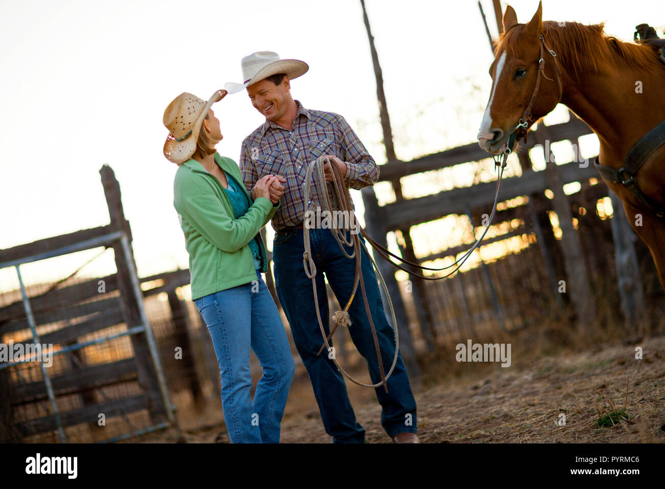Happy rancher smiling and holding hands with his wife Stock Photo - Alamy