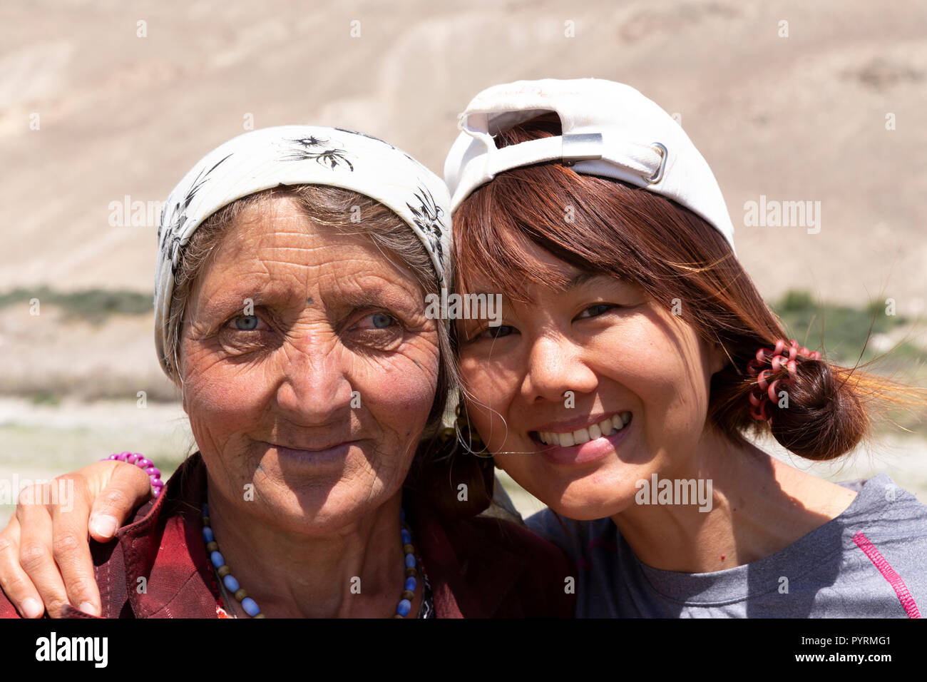 Old Wakhi woman near Panj River smiles with trekker, Wakhan Valley ...