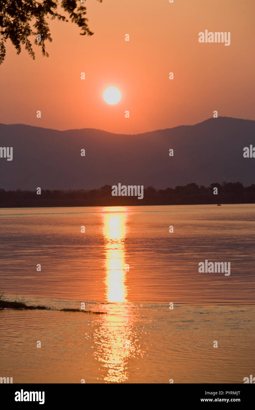 Sun setting over a river Stock Photo - Alamy