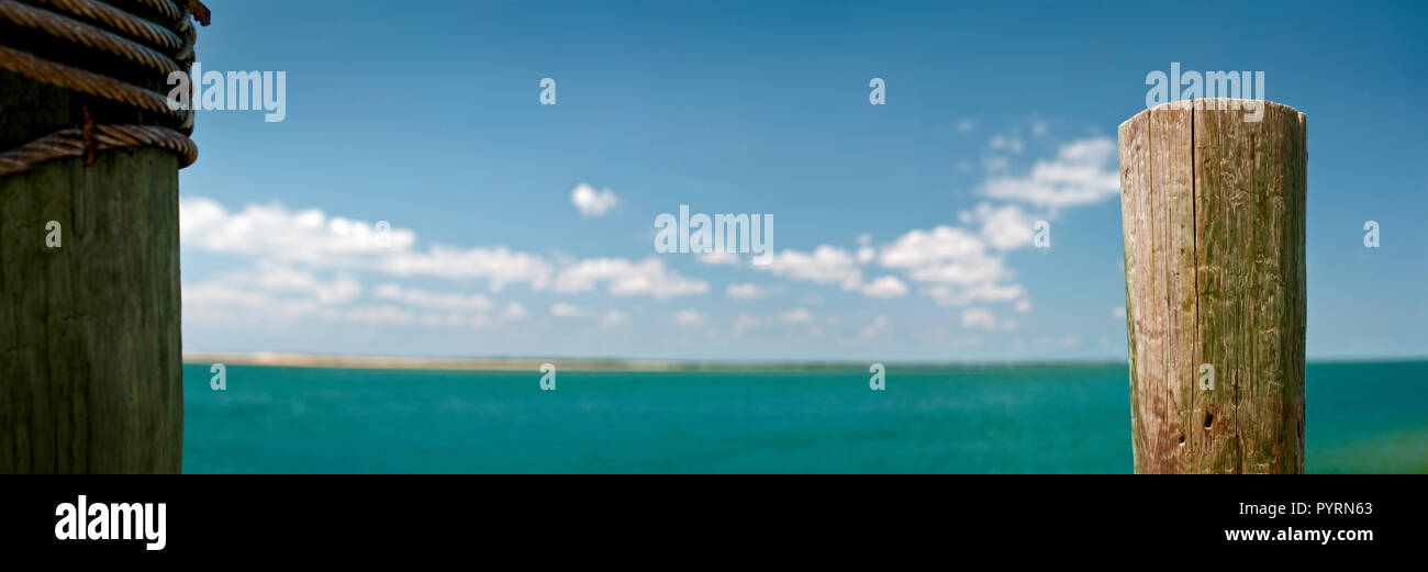 Wooden mooring posts and the ocean Stock Photo - Alamy