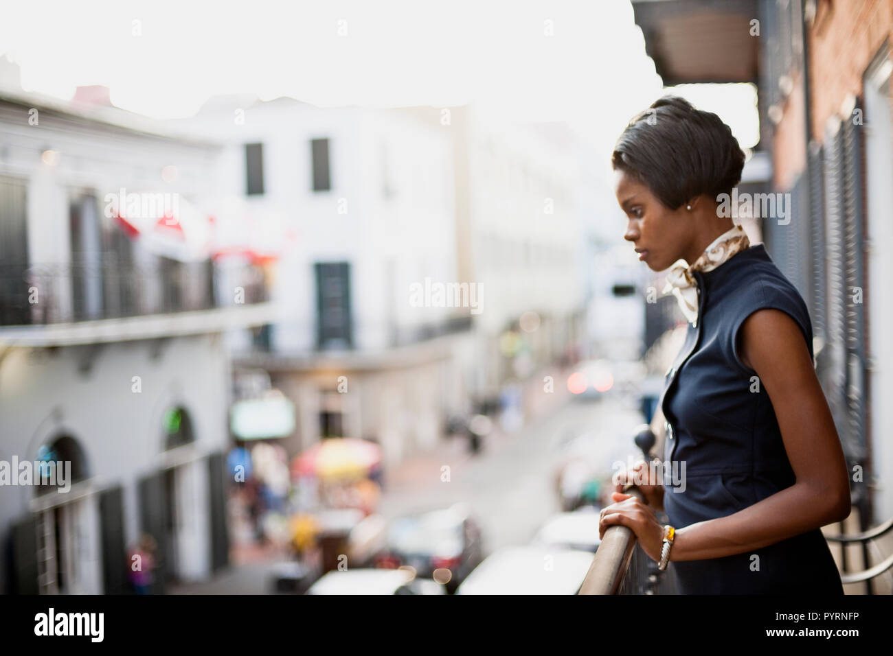 Woman looking over balcony Stock Photo - Alamy