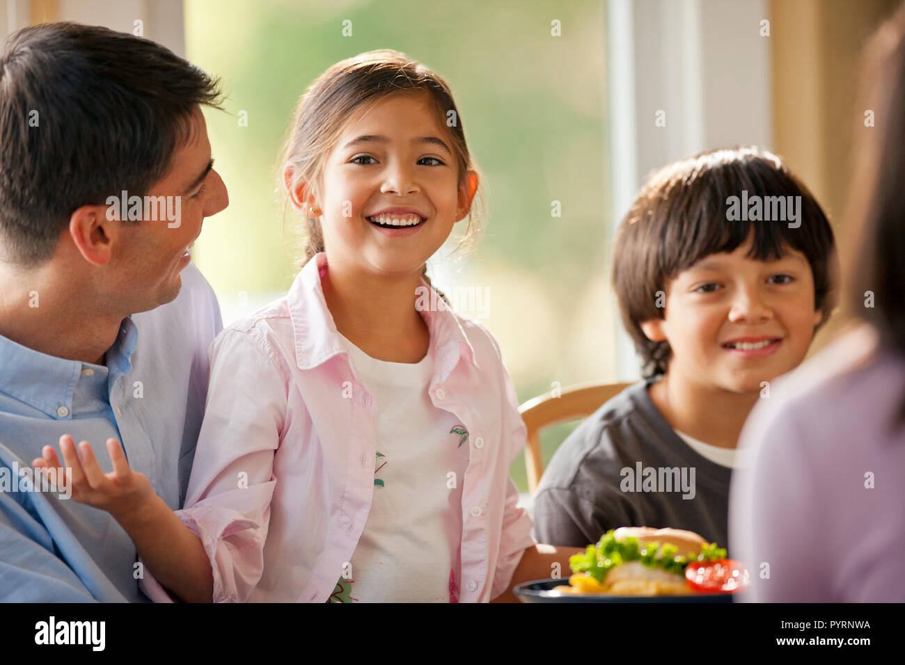Happy family having fun eating at a dining table Stock Photo - Alamy