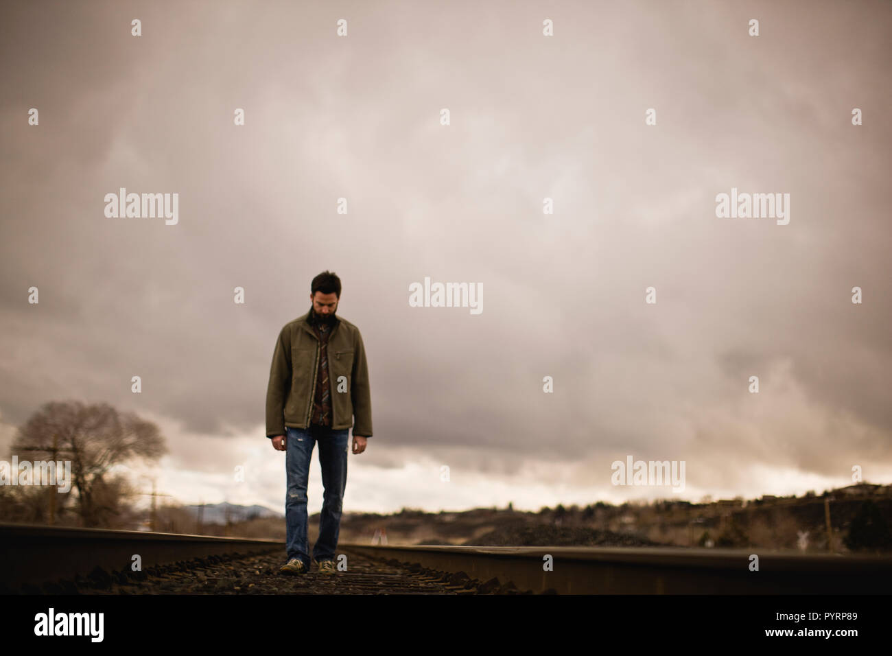 Man standing alone on train tracks Stock Photo - Alamy