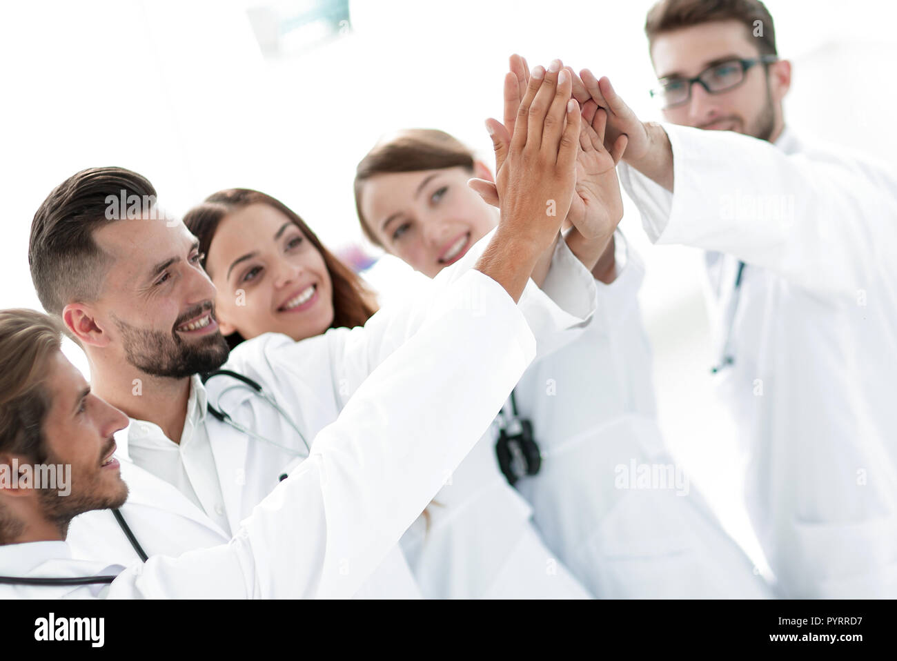 group of doctors giving each other a high five Stock Photo - Alamy