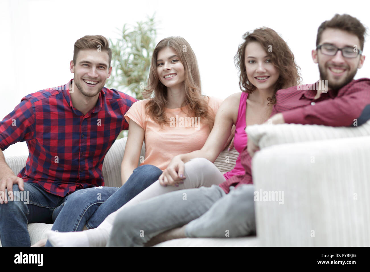 group of cheerful friends sitting on sofa Stock Photo - Alamy
