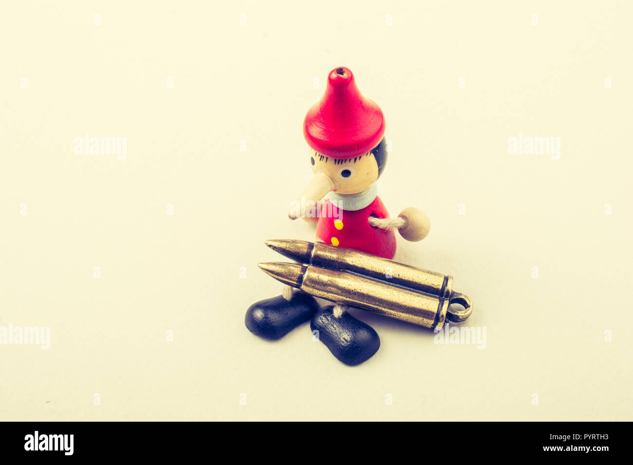 Bullet and wooden pinocchio doll with his long nose Stock Photo - Alamy
